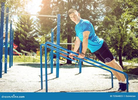 man doing push ups outdoor on metal bars stock image image of force