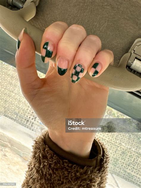 자동차 손잡이를 들고 인식 할 수없는 여자의 클로즈업 이미지 네일 아트를 표시하는 왼손 녹색 체크 패턴 네일 바니시 매니큐어 디자인 자동차 인테리어 배경 전경에 초점을