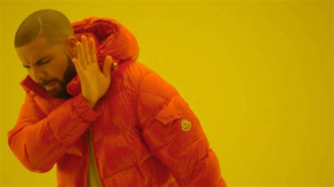A Man In An Orange Jacket Holding His Hand To His Ear And Covering His Face
