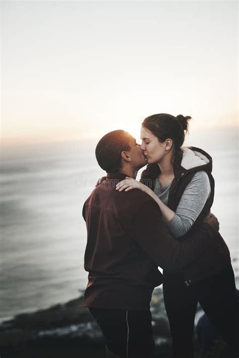 Kissing Each Other In Celebration An Affectionate Young Couple Kissing