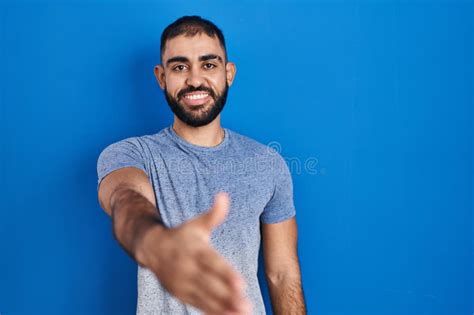 Middle East Man With Beard Standing Over Blue Background Smiling