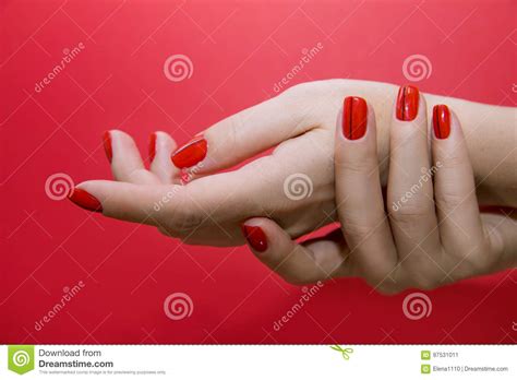 Manos Femeninas Hermosas Con La Manicura Roja Y El Clavo Aislados