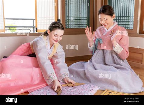 Korean And Caucasian Girls Wearing Hanbok Playing Yut Korean