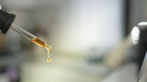 A Dropper Pouring Liquid In To The Black Bottle Free Stock Video