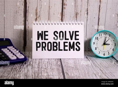 An Alarm Clock A Blue Calculator And The Words We Solve Problems Stock