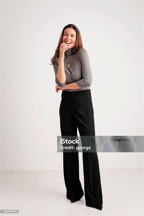 스웨터와 검은색 바지를 입고 외딴 배경에 서 있는 매력적인 여성의 전체 길이 샷 전신에 대한 스톡 사진 및 기타 이미지 전신 여성 30 39세 Istock
