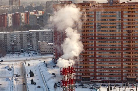 높은 Multistorey 주거 건물 및 작은 건물의 배경에 대 한 건물을 위한 열 생산을 위한 공장에서 수직으로 위쪽으로는