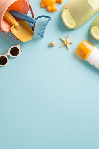 휴가 개념에 아이를 위한 재미있는 활동 슬리퍼와 선글라스 해변 어린이 장난감 자외선 차단제 조개껍데기의 평면도 수직 사진 복사 공간이 있는 파란색 격리된 배경 0명에 대한