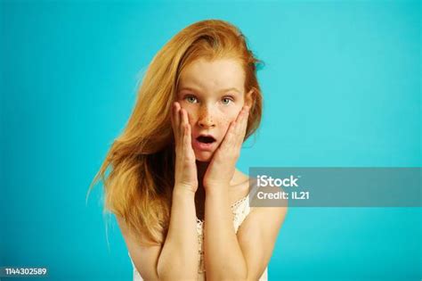 빨간 머리를 가진 기 절 한 소녀의 초상화는 뺨에 자신의 손을 두고 놀라움과 충격을 표현 놀라움의 뚜렷한 감정을 보여줍니다 6