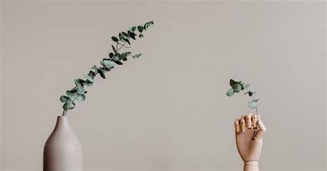 현대 꽃병에 마른 유칼립투스 가지와 실내 나무 테이블에 나무 손 텍스트를 위한 빈 공간입니다 현대 홈 인테리어 디자인 요소 배경입니다 사진 Unsplash의