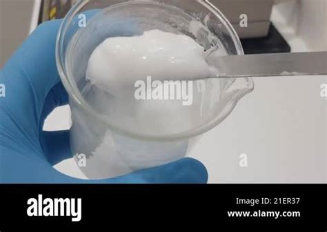 Close Up Footage Of A Beaker Containing A White Emulsion Being Stirred
