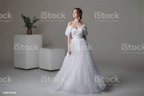 미니멀한 흰색 스튜디오 인테리어에 긴 레이스 드레스를 입은 아름다운 젊은 신부 모델 웨딩 사진 결혼 의식에 대한 스톡 사진 및