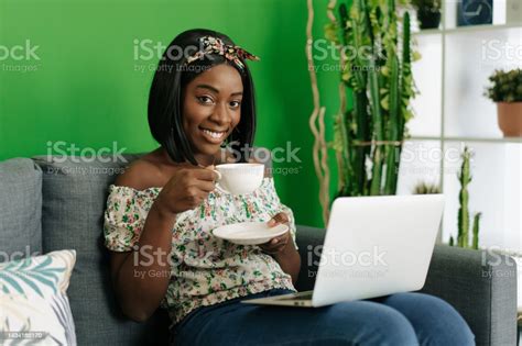 소파에 앉아있는 집에서 노트북 컴퓨터에서 일하는 젊은 아프리카 여성 20 24세에 대한 스톡 사진 및 기타 이미지 20 24세 가정의 방 거실 Istock