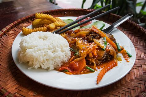 맛있는 요리 베트남의 길거리 레스토랑에서 테이블에 야채와 튀긴 해산물과 삶은 쌀 접시 매운 베트남 음식 카레와 밥 밥에 젓가락