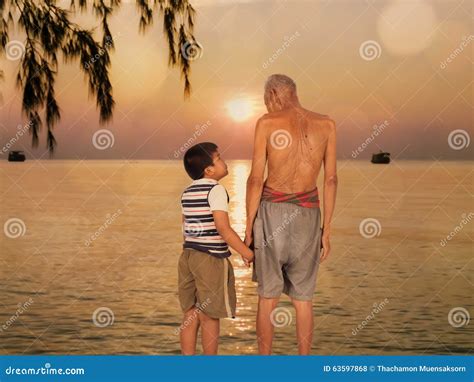 Abuelo Y Nieto Que Se Colocan En El Backgroun De La Puesta Del Sol De
