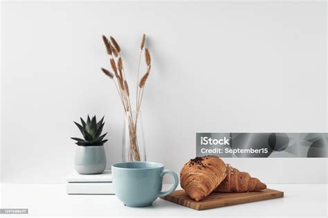 나무 스탠드에 크루아상과 머그잔 꽃병과 책 흰색 배경에 식물이있는 냄비 실내 장식 미니멀리즘의 친환경 소재 공간을 복사하고 모의합니다 0명에 대한 스톡 사진 및 기타 이미지
