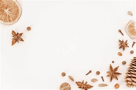 Mulled 와인을위한 향신료 향신료 모형 테이블에 향신료와 크리스마스 장식 하얀 배경에 따뜻한 겨울 음료를위한 소나무 콘과