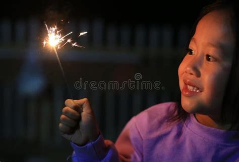 Close Up Little Asian Girl Playing Fire Sparklers In The Dark At Night