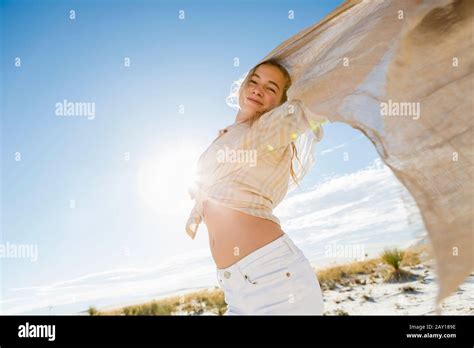 13 Year Old Girl With Arms Raised Holding A Light Shawl Dancing In Open