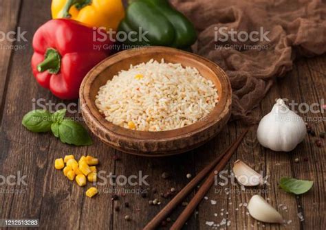 삶은 긴 곡물 Basmati 쌀 과 나무 테이블 배경에 야채와 막대기와 옥수수 마늘과 바질 파프리카 후추 맨 위 보기 건강한