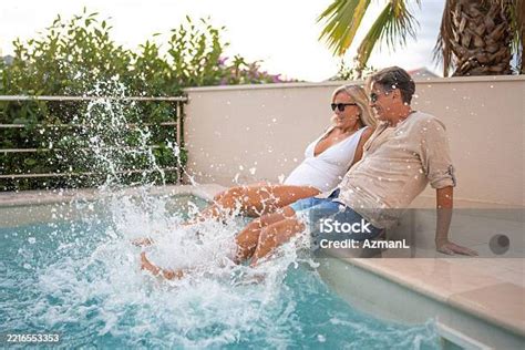 성숙한 커플이 열대 환경에서 화창한 오후에 수영장 옆에서 물을 튀기고 있습니다 2명에 대한 스톡 사진 및 기타 이미지 2명 55 59세 건물 외관 Istock