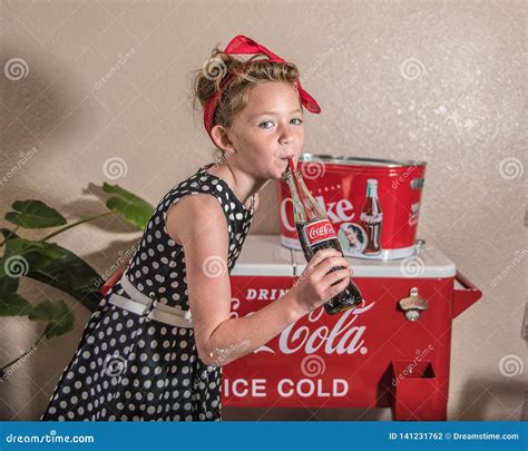 Cute Girl Drinking A Coca Cola A 50`s Style Restaurant With Sunglasses