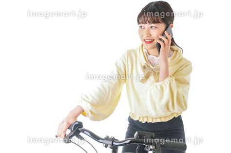 自転車でスマホを使う若い女性の写真素材 174613017 イメージマート