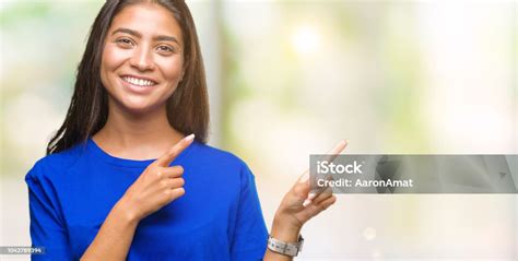 웃 고 옆에 두 손과 손가락으로 가리키는 카메라 보고 격리 된 배경 위에 젊은 아름 다운 아랍 여자 가리키기에 대한 스톡 사진 및 기타 이미지 Istock