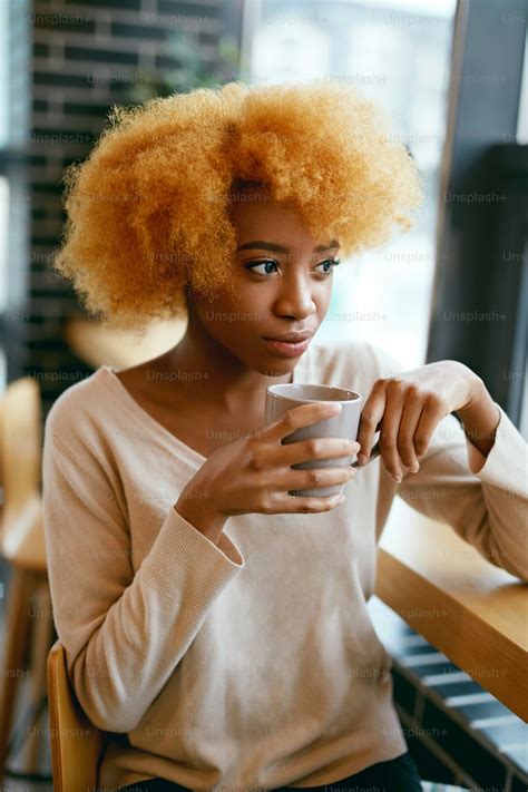 창문 근처 카페에서 커피 음료를 마시는 아름다운 소녀 카페에서 뜨거운 음료의 Cu0p와 함께 캐주얼 옷을 입은 젊은 웃는 아프리카 여성의 초상화 고해상도 사진