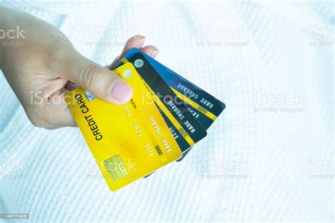 여자는 여러 신용 카드를 들고 신용 카드를 통해 상품에 대한 지불을 지불하고 지출 할 신용 카드를 선택하고 있습니다 금융 및 은행 개념입니다 개념에 대한 스톡 사진 및 기타