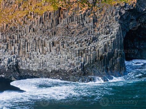 Hexagonal Basalt Columns On Icelandic Coast With Ocean Waves Crashing
