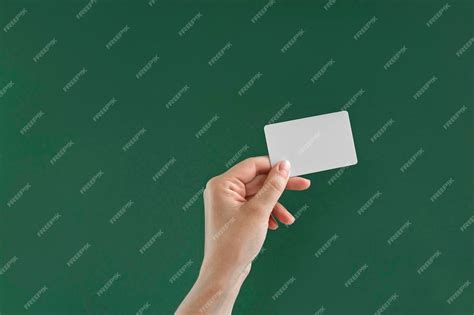 Premium Photo Female Hand Holding White Credit Card Isolated On Green
