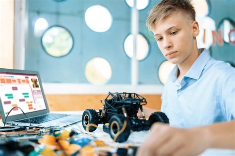 Premium Photo Boy Consider Parts Of Robotics Car While Learning In