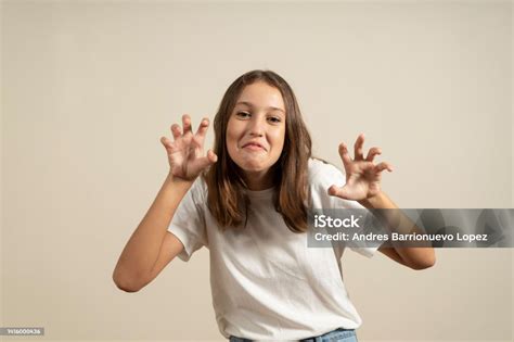 위협의 감정에 베이지 색 배경에있는 스튜디오의 아름다운 학령기 소녀는 발톱으로 타이어를 모방합니다 12 13세에 대한 스톡 사진 및 기타 이미지 Istock