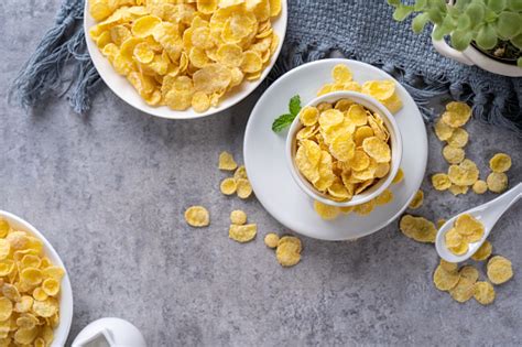 회색 시멘트 배경에 옥수수 플레이크 그릇 과자 상단 보기 플랫 평신도 레이아웃 디자인 신선하고 건강한 아침 식사 개념 개념에