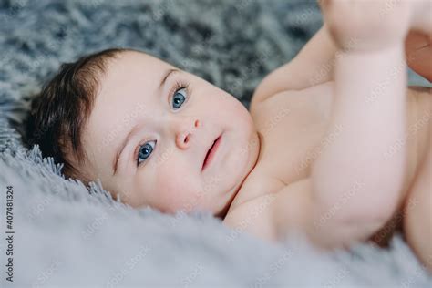 Six Months Old Naked Baby Lying On Soft Grey Sheet And Holding Her Toe Stock Photo Adobe Stock