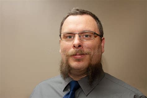 A Man With A Beard And Glasses Is Wearing A Blue Tie Stock Image