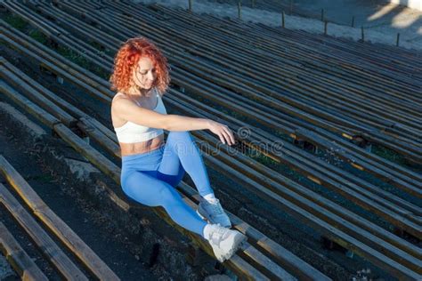 Junge Sportlerin Redhaired Die Auf Einer Holzbank Eines Sportstadions