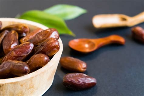 근접 촬영 달콤한 말린 대추 과일 또는 Kurma 라마단 음식 자연 빛입니다 선택적 초점입니다 검은 배경에 닫습니다 상위 뷰