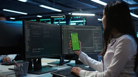 Premium Stock Video Worker Overseeing Data Center Using Green Screen Mobile Phone