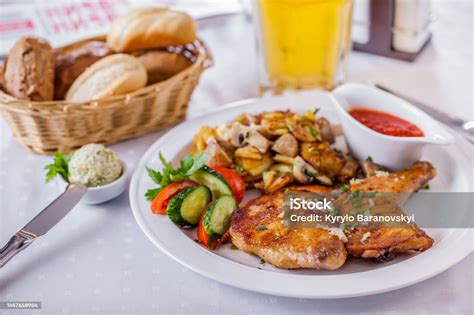 오이 파슬리 마늘 토마토 빵 바구니 흰색 원형 접시에 맥주 한 잔과 함께 소스에 프라이드 치킨 필레 수평 방향 바베큐그릴에 대한