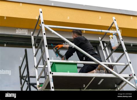 Window Cleaner On A Portable Scaffolding Rack Cwashing Windows Of A