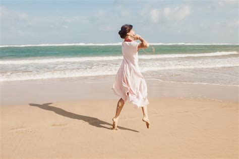 Mulher caminhando na areia da praia Foto Grátis