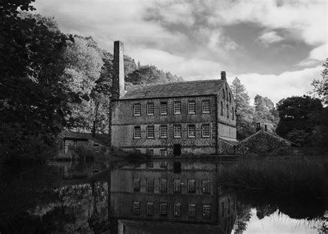 A Black And White Photo Of A Building Near A Body Of Water Photo Free