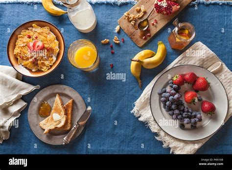 Assorted Breakfast Setting Cold Cereal Fruit Toast And Orange Juice