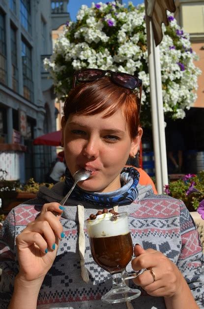 Premium Photo A Young Redhaired Girl Sits In The Shade Near A Cafe