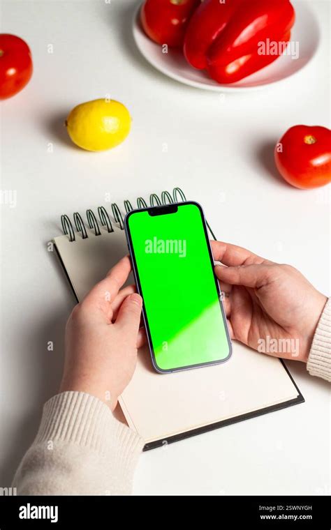 planning healthy menu concept smartphone with green screen in hands
