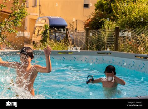 Caucasian Brother And Sister Play Splashing In A Small Pool In Their