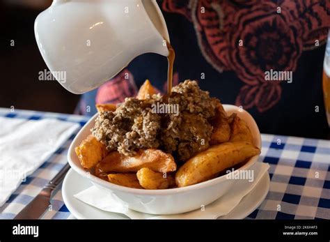 Scottish traditional snack food, hand cut potato chips topped with ...