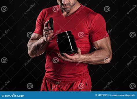 Bello Giovane Uomo Atletico Che Tiene Un Barattolo Di Nutrizione Di